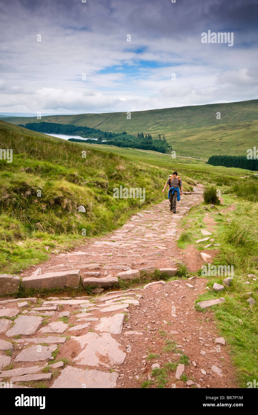 A lone hiker walking up the path to the summit of Pen y Fan in the ...