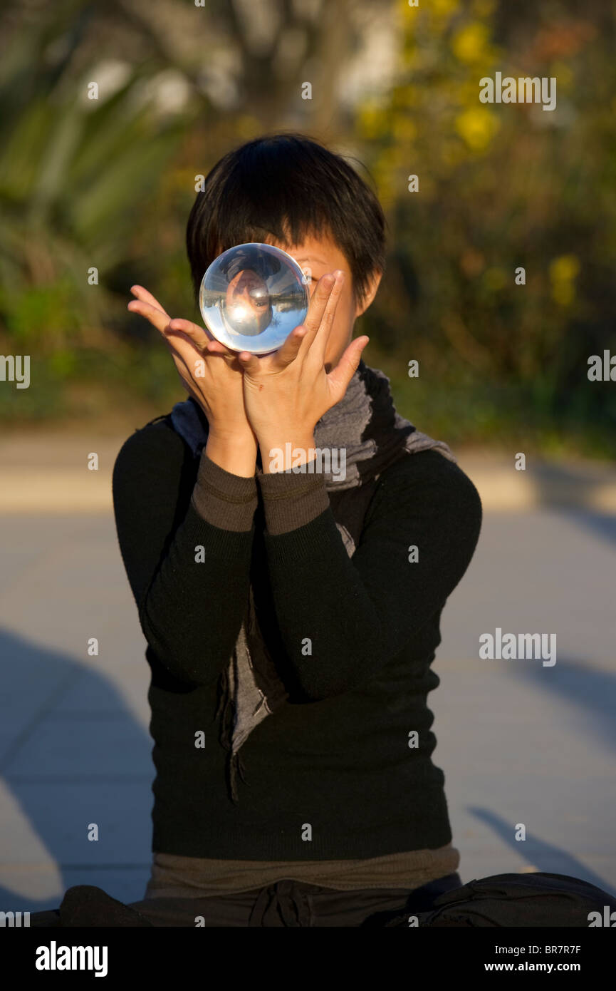 Female Chinese street performer working with glass sphere on the South ...