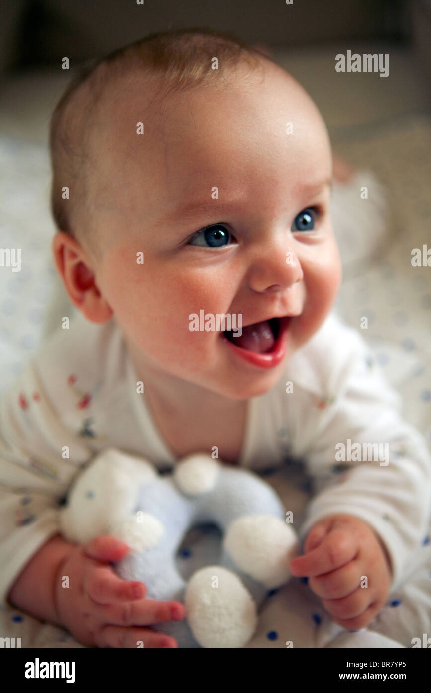 Baby boy with blue eyes smiling with rattle Stock Photo - Alamy