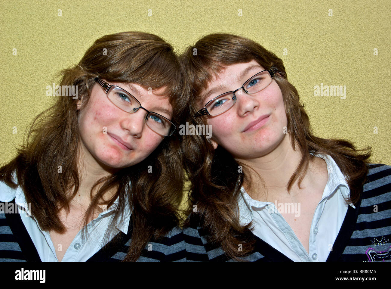 Identical female teenaged twins dressed alike in same clothing outfits ...