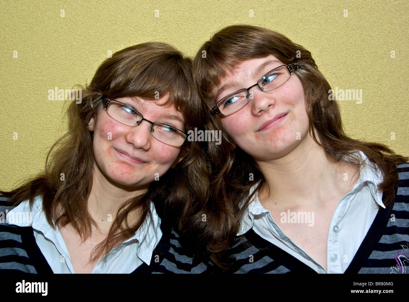 Identical female teenaged twins dressed alike in same clothing outfits ...