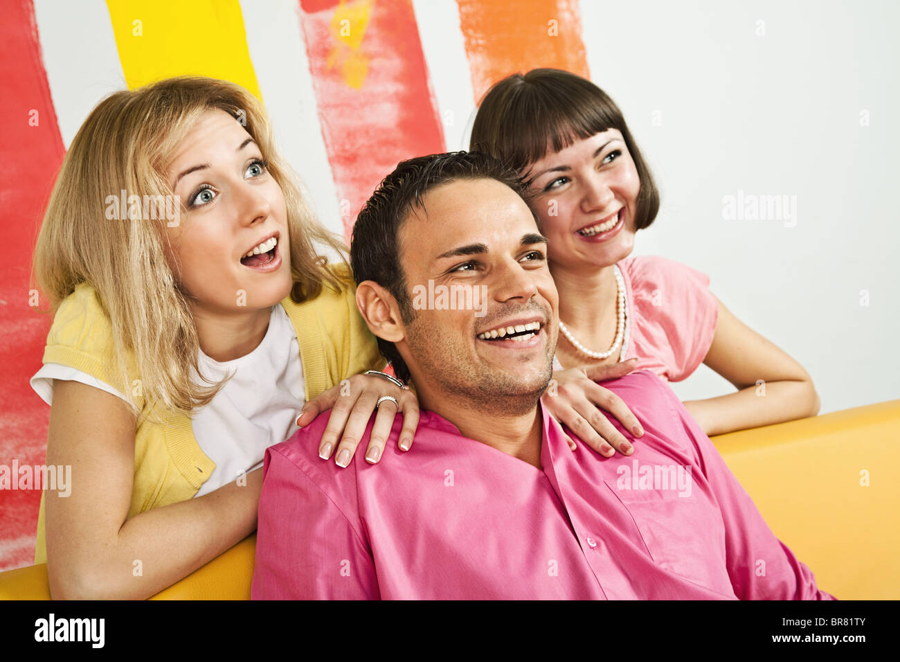 Group of three happy young people watching something amusing Stock ...