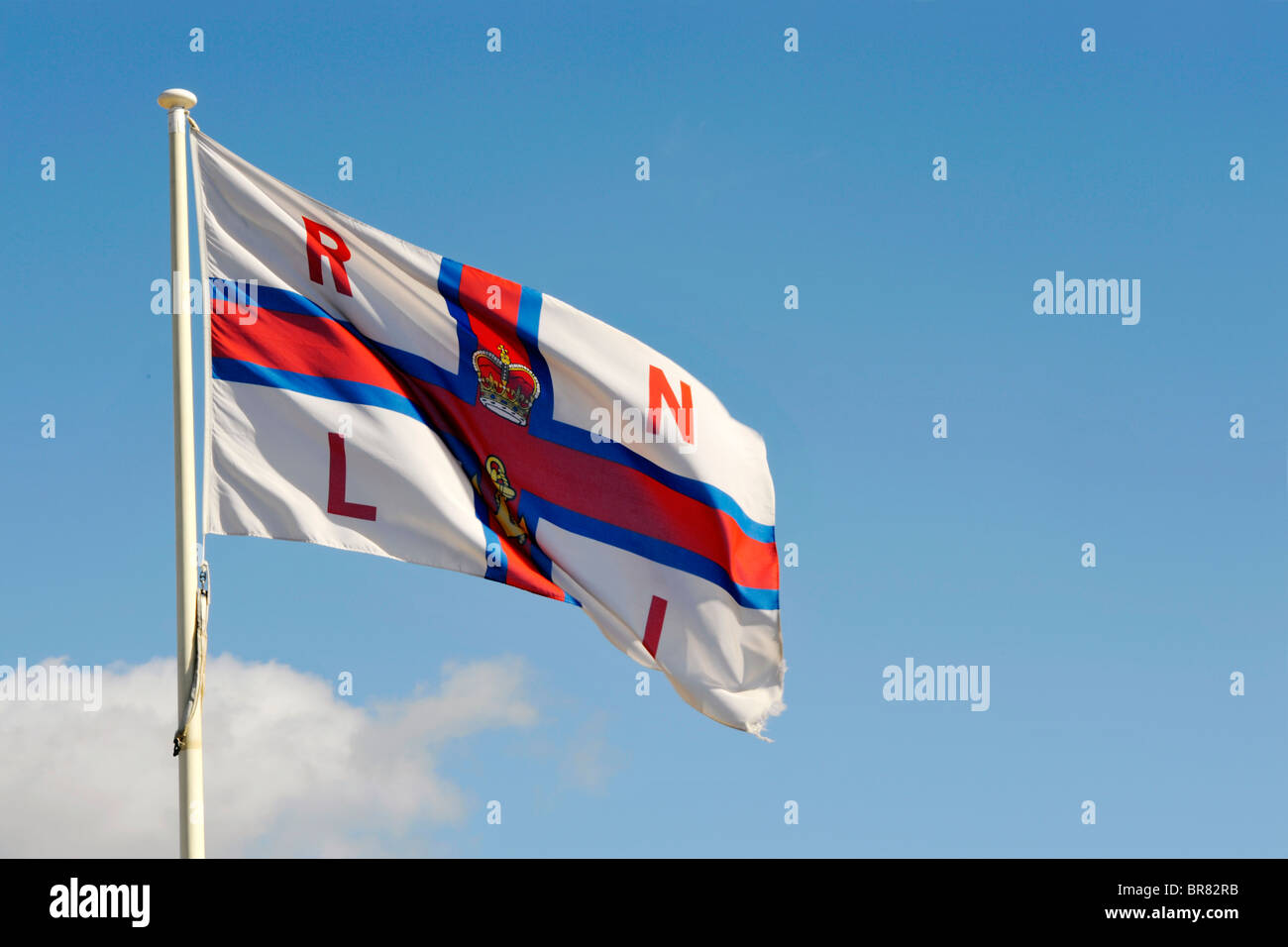 royal national lifeboat institute flag flying against a blue sky ...