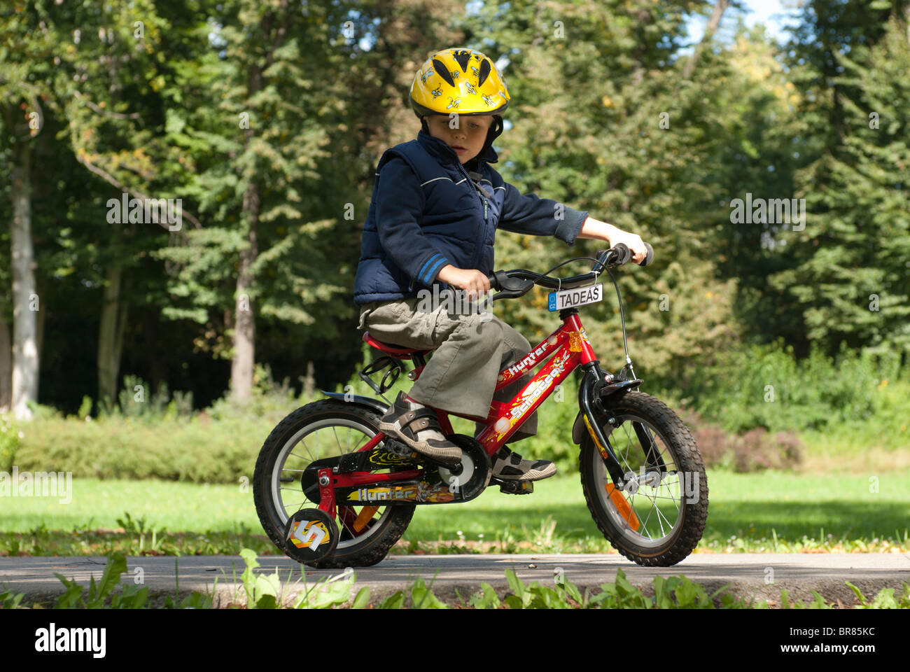 Boy Learning to Ride Bicycle with stabilizing wheel bike Stock Photo ...
