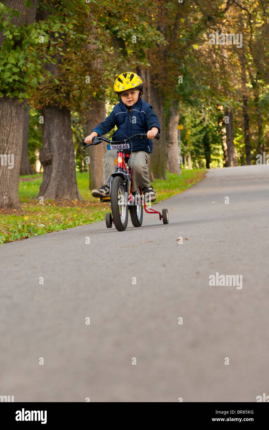 Boy Learning to Ride Bicycle with stabilizing wheel bike Stock Photo ...