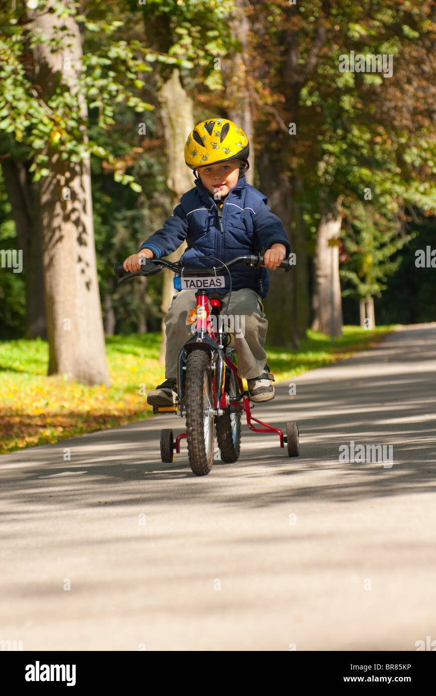Boy Learning to Ride Bicycle with stabilizing wheel bike Stock Photo ...