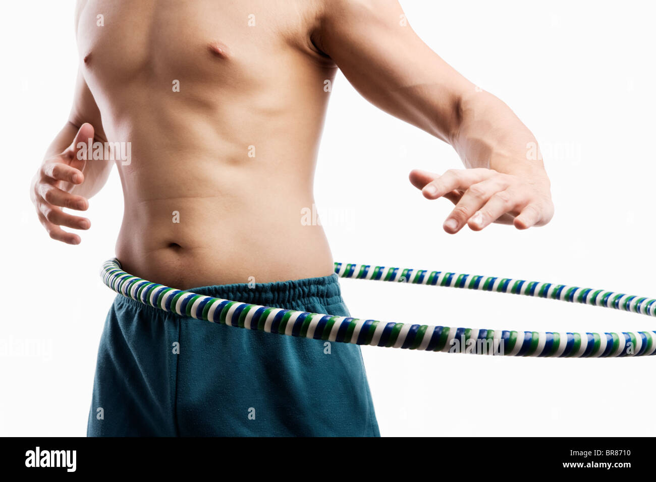 Man, showing only body part playing hula hoop against white background ...