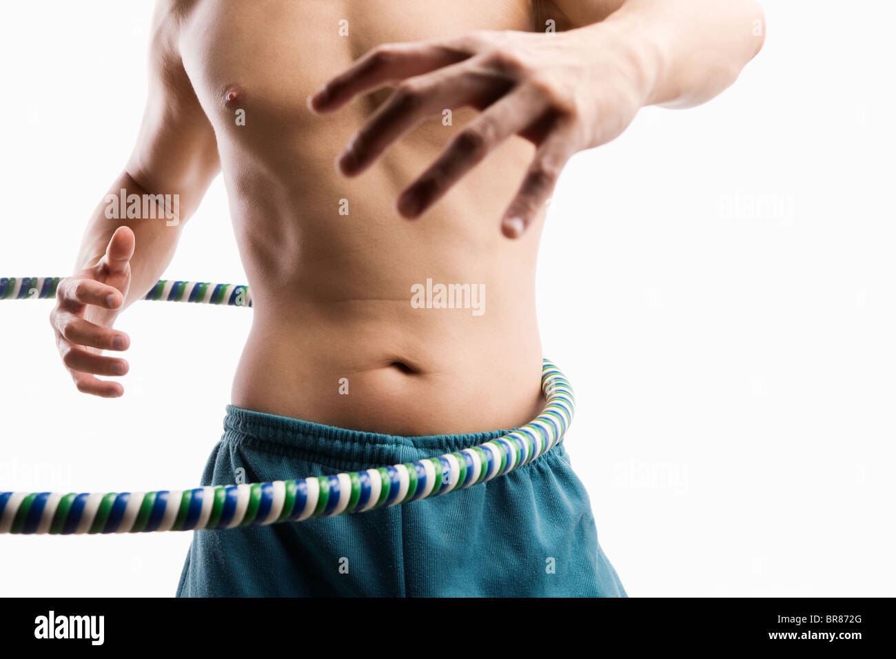 Man, showing only body part playing hula hoop against white background ...