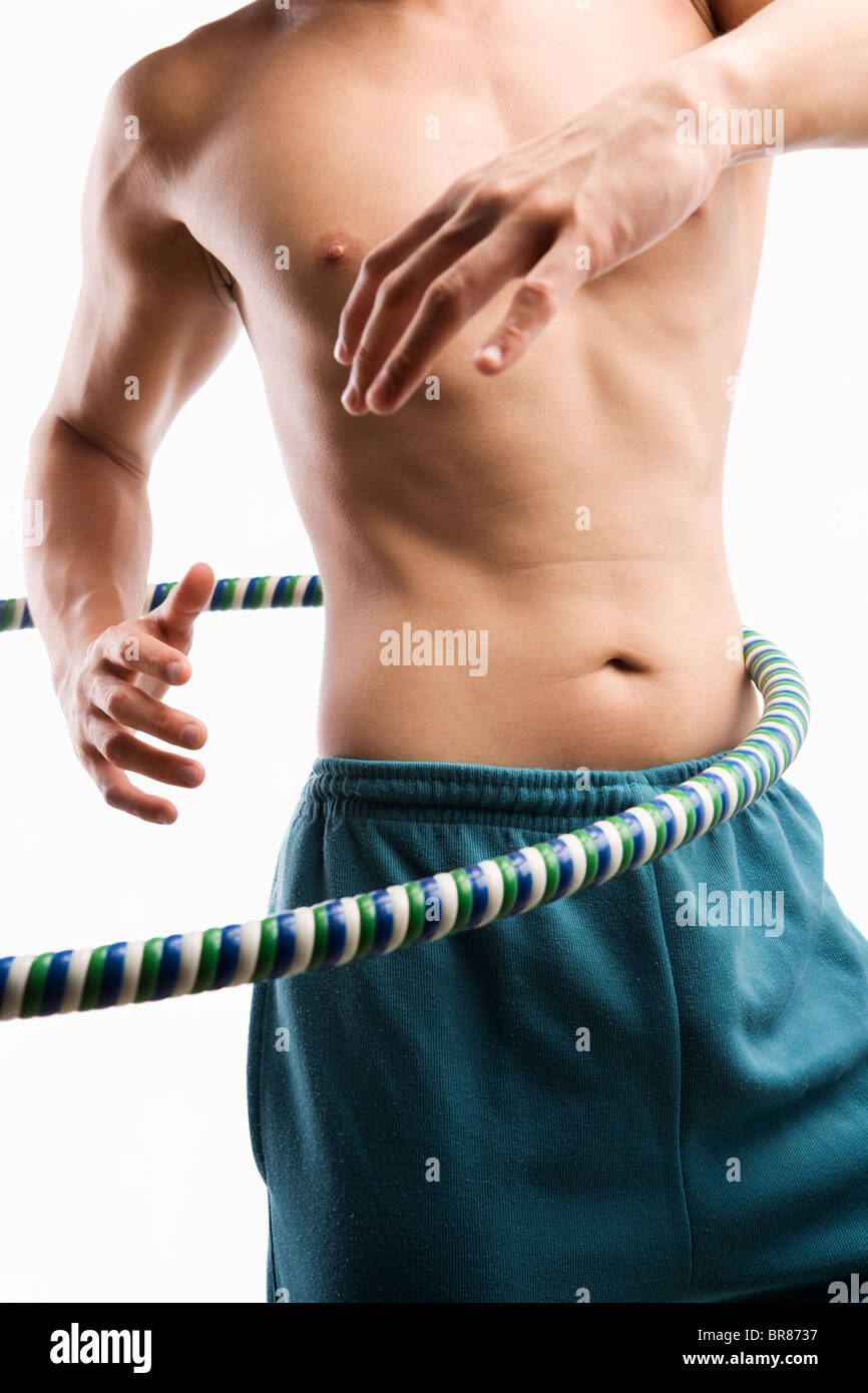 Man, showing only body part playing hula hoop against white background ...