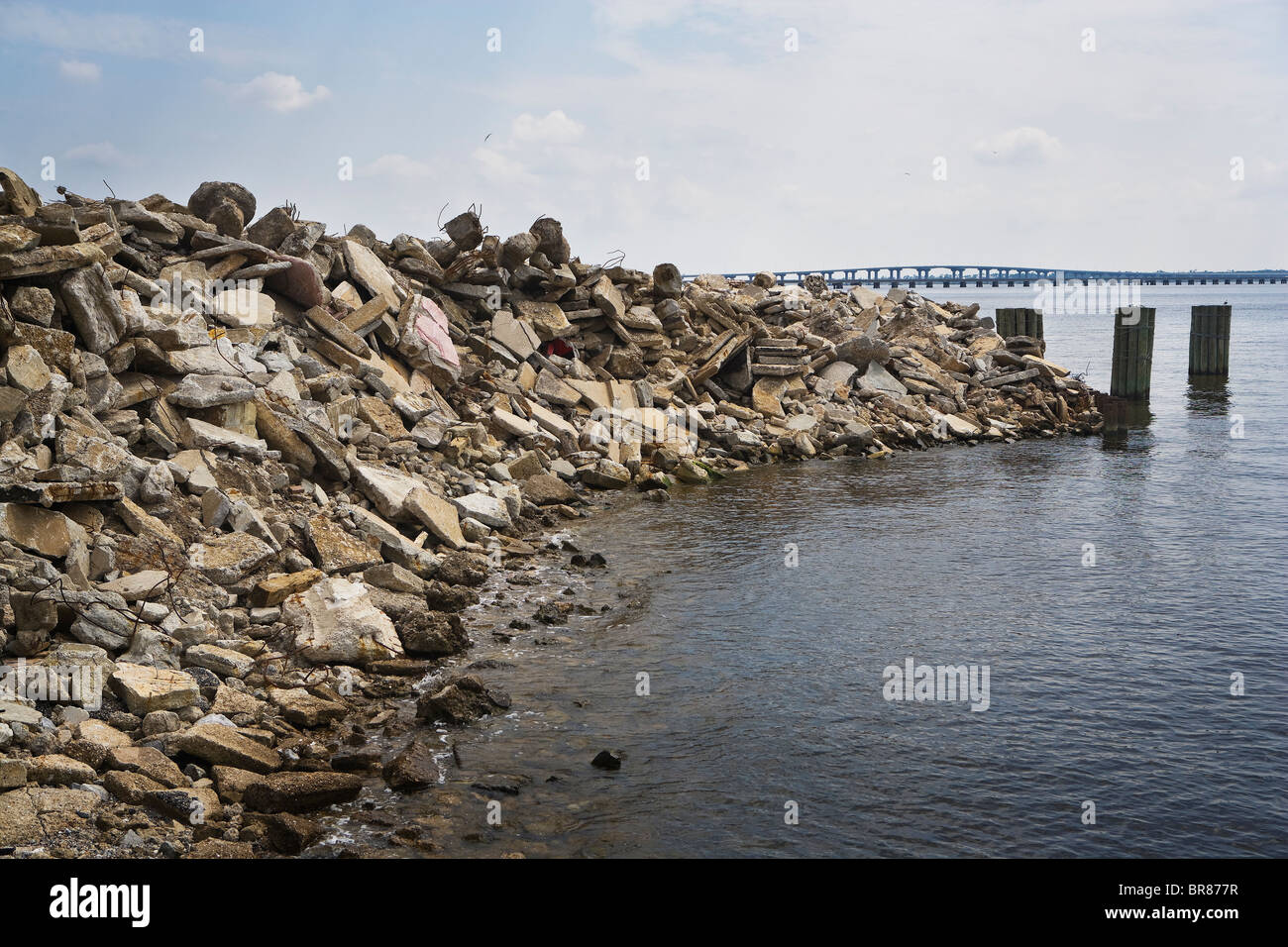 Red oil boom in the water in a quiet bay with wooden pilings and a ...
