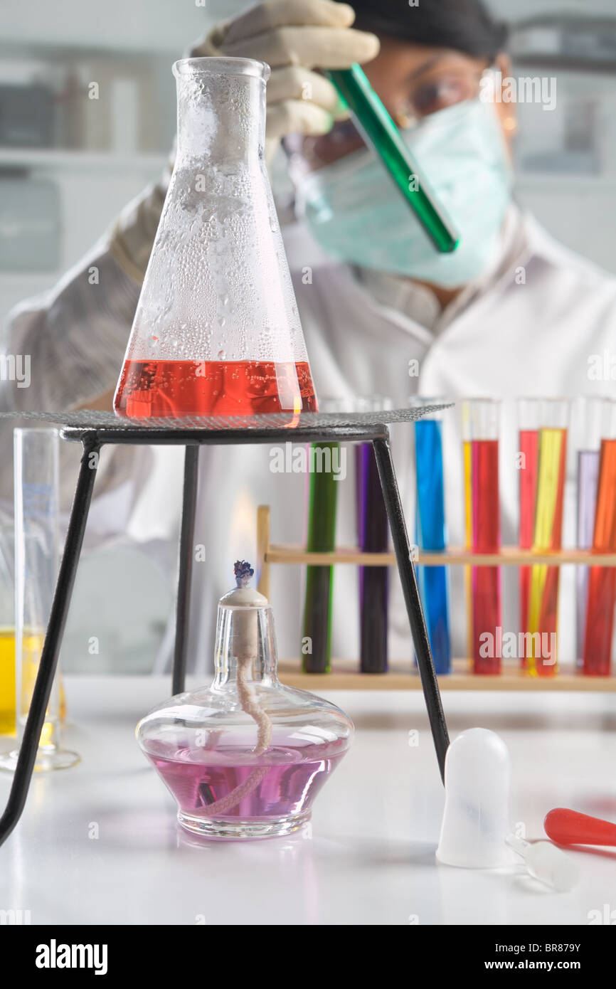 Chemical in baker glass boiled, with scientist working on background ...