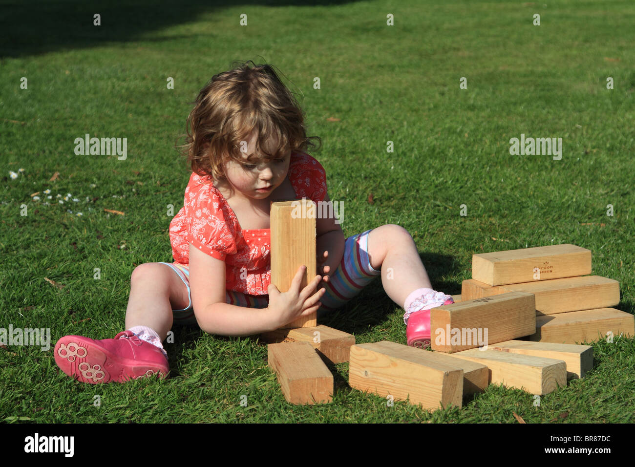 Girl playing with wooden blocks Stock Photo - Alamy