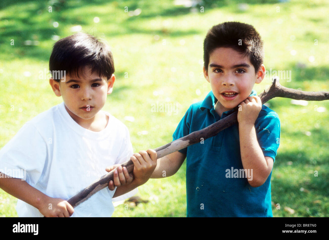 Hispanic boy cousin play stick carry share fun relative relation ...