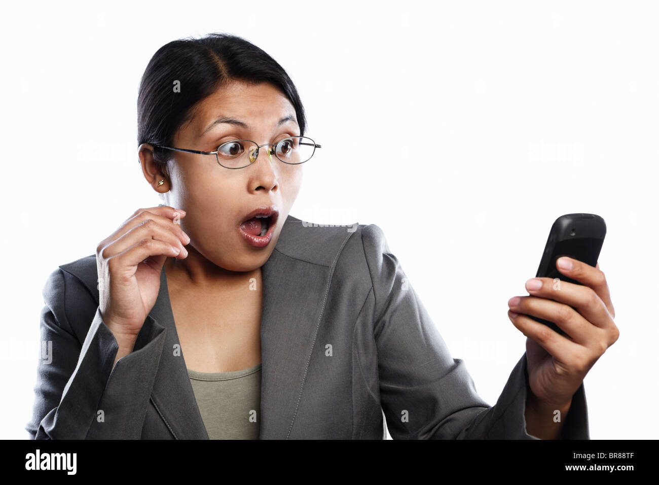 Asian businesswoman surprised expression using video call of her cell phone feature, isolted on ...