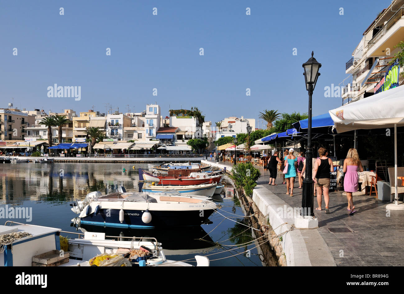 People walking around Voulismeni lagoon, Agios Nikolaos, Crete island ...