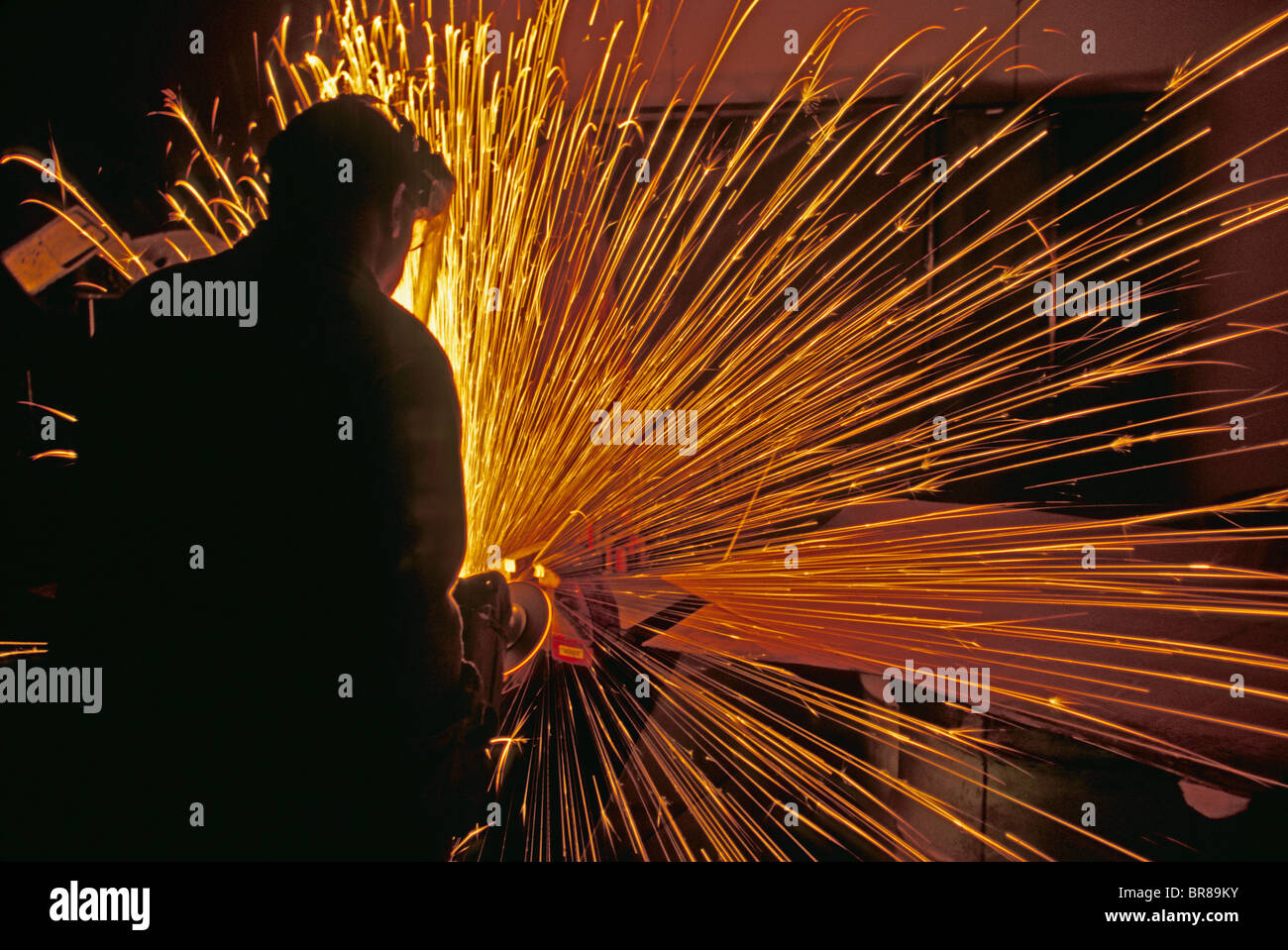 Welder grinding the hull of a yacht Stock Photo - Alamy