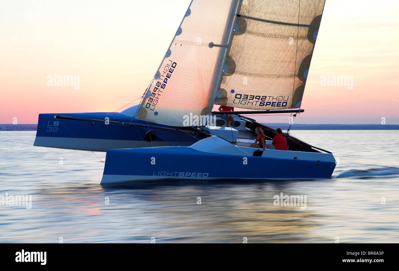 Lightspeed 32 cruising catamaran sailing at sunset Stock Photo - Alamy