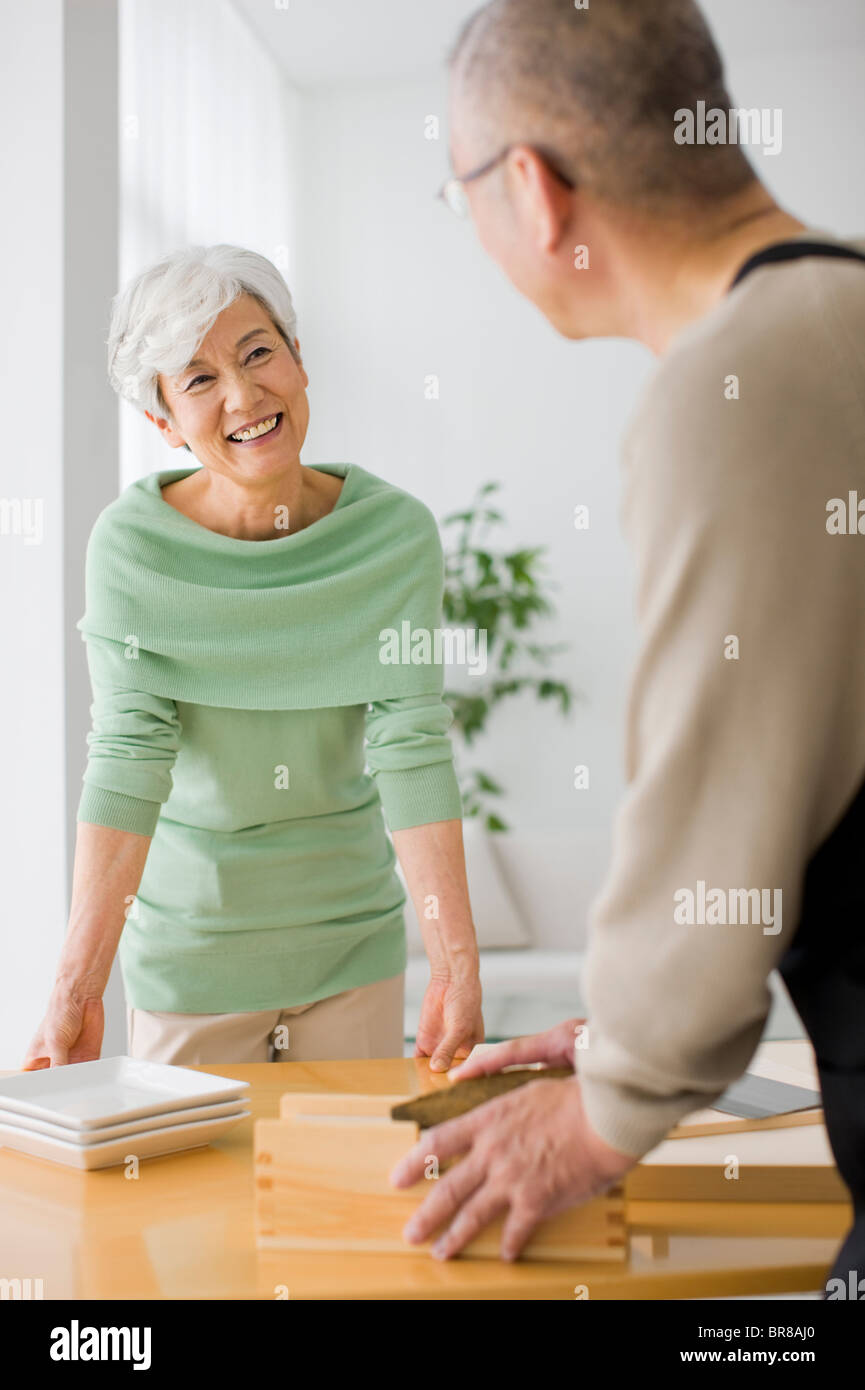 Mature woman smiling to man grating dried bonito Stock Photo - Alamy