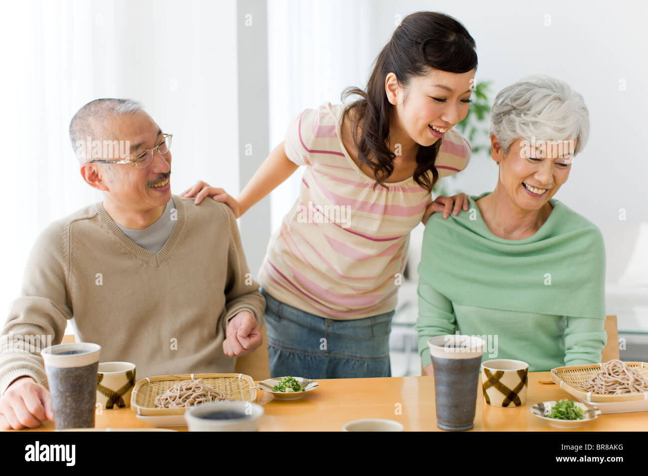 Family at dining table, smiling Stock Photo - Alamy