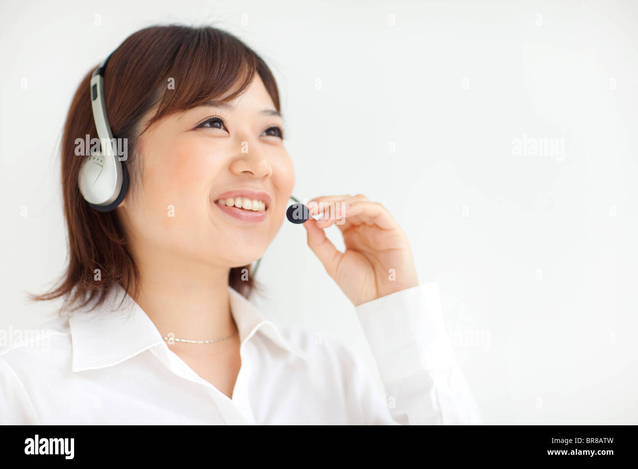 Young businesswoman wearing headset, smiling, white background Stock ...