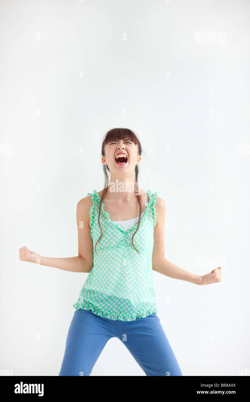 Young woman shouting, white background Stock Photo - Alamy