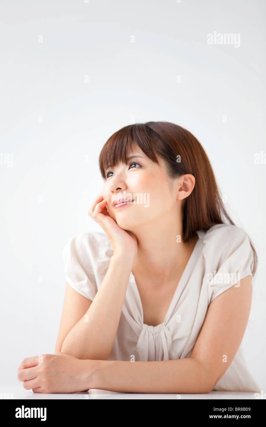 Young woman on white background, resting chin on hand Stock Photo - Alamy