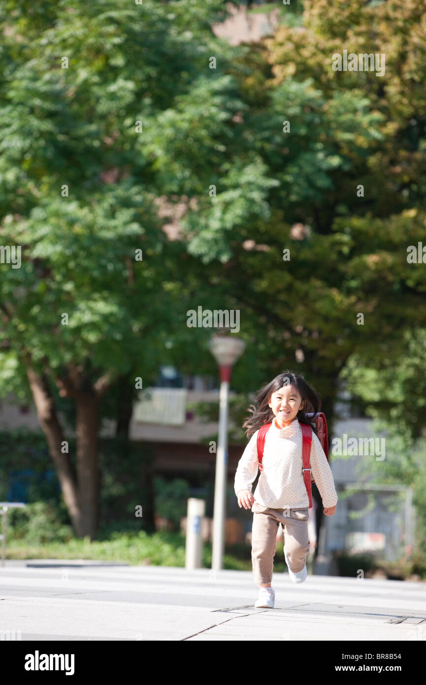 Girl with backpack running Stock Photo - Alamy