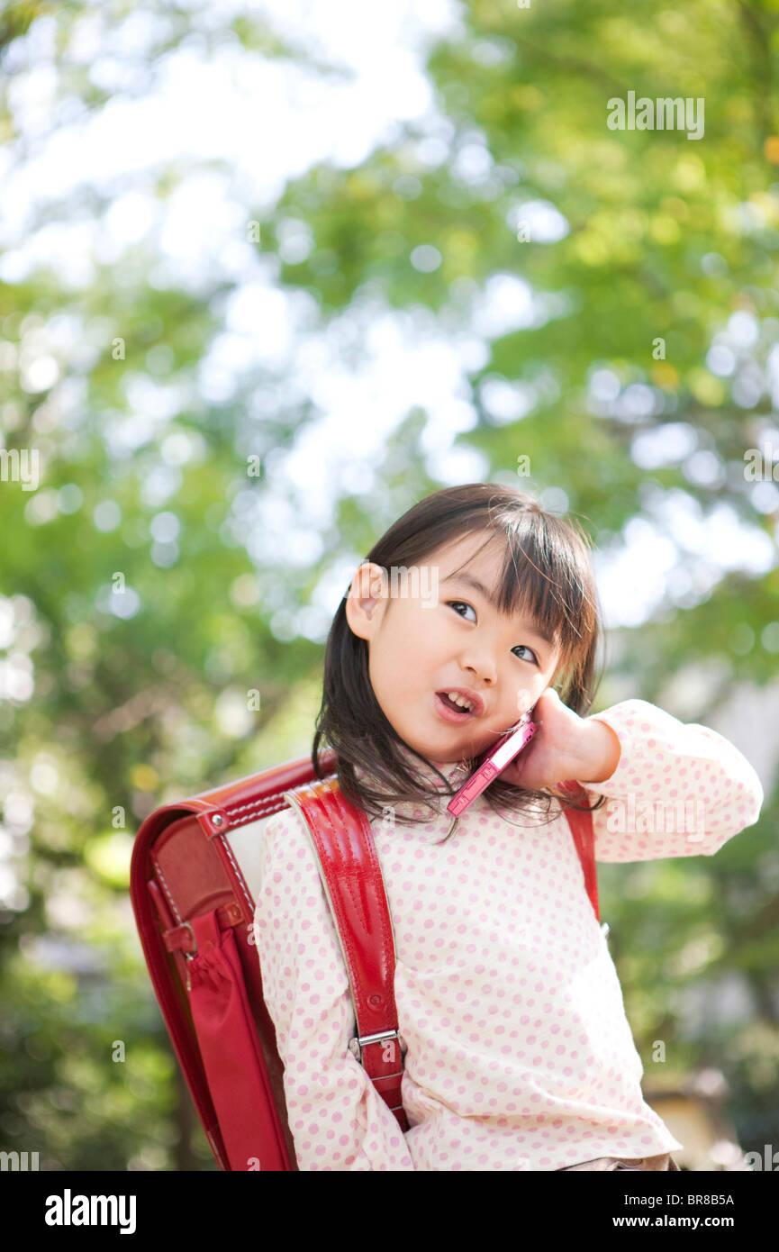 Girl with backpack using mobile phone Stock Photo - Alamy