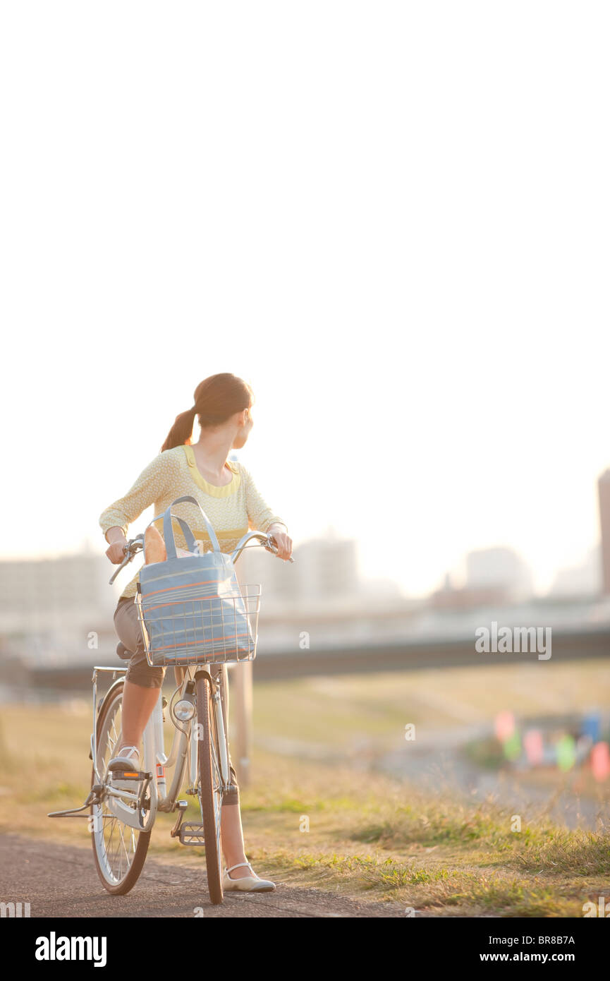 Woman riding bicycle, looking back, copy space Stock Photo - Alamy
