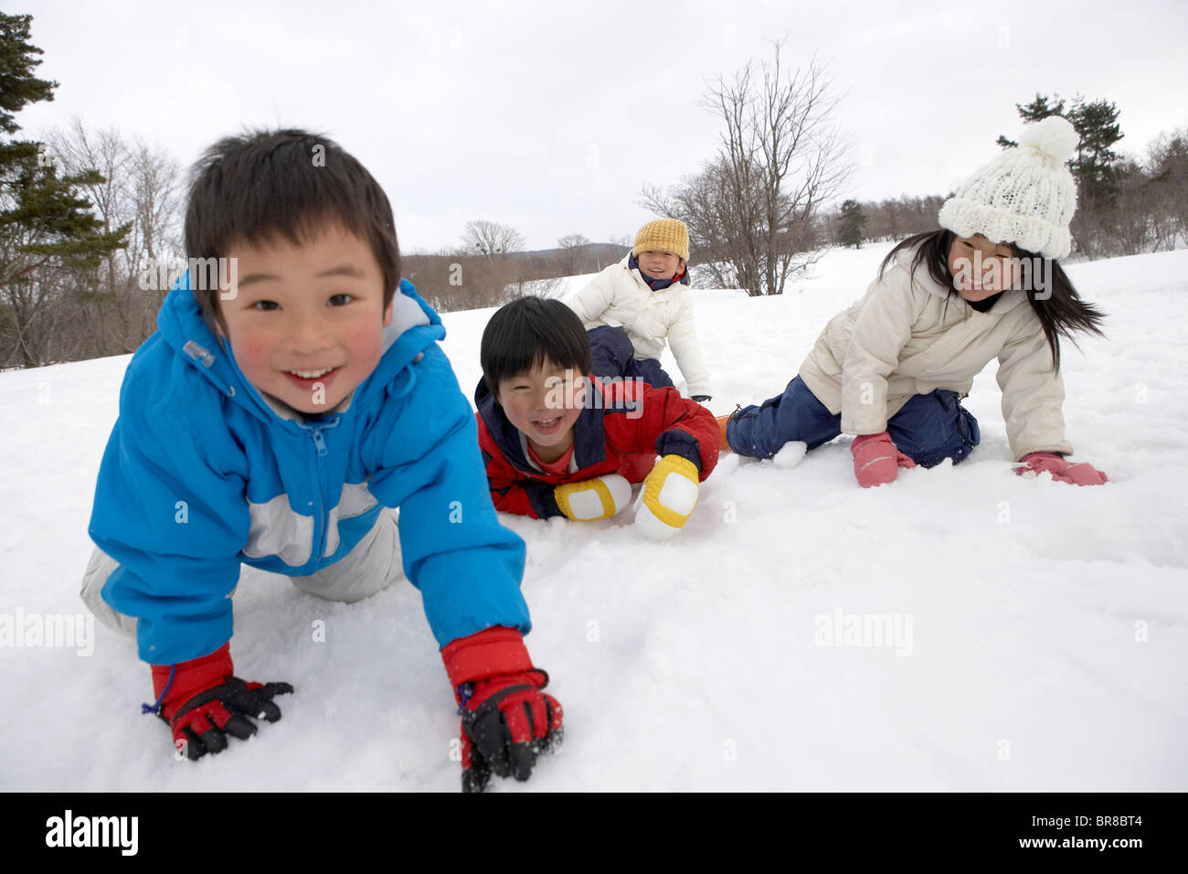 Kids playing in snow Stock Photo - Alamy