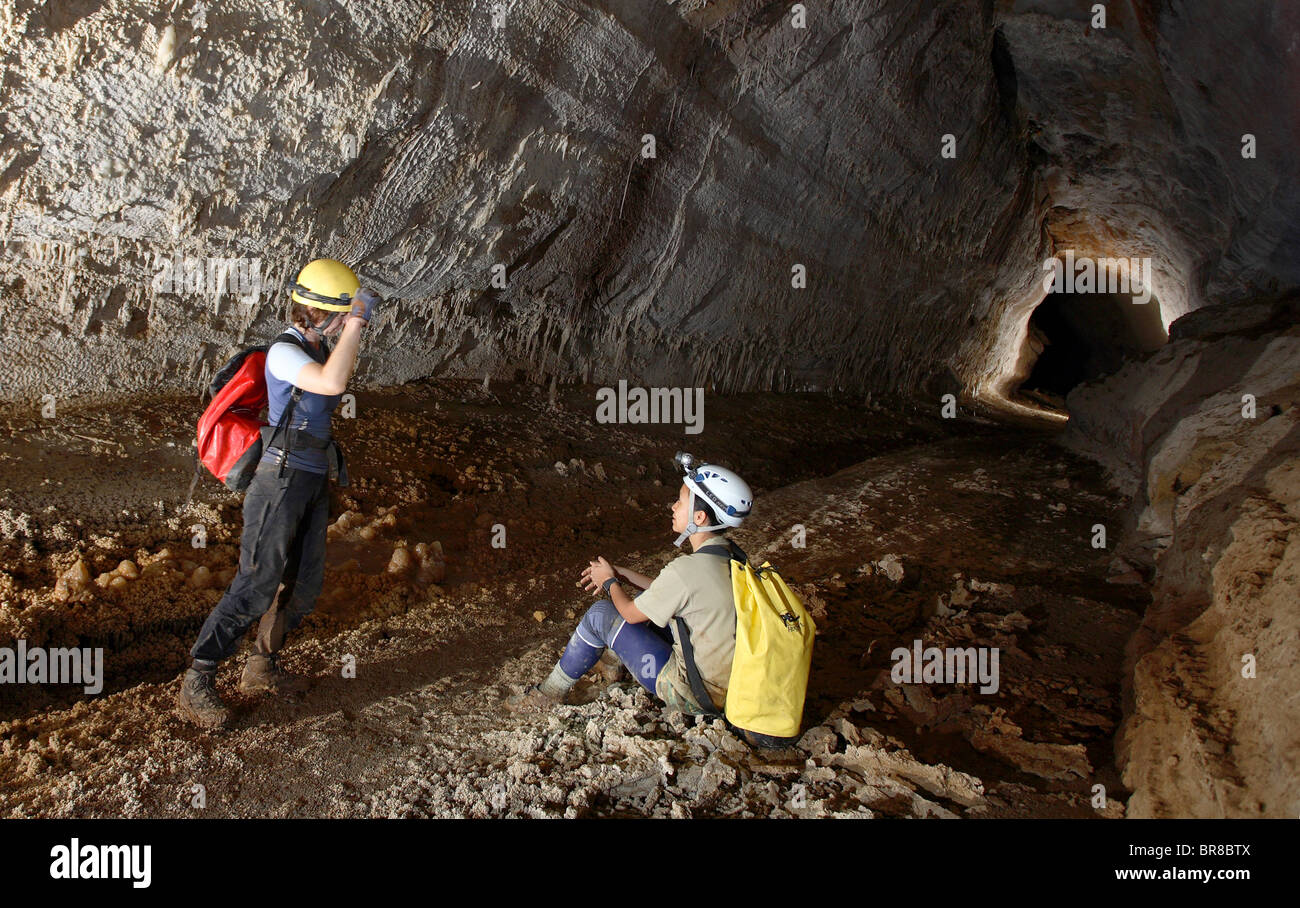 Two female cave explorers stop for a rest whilst exploring this ...