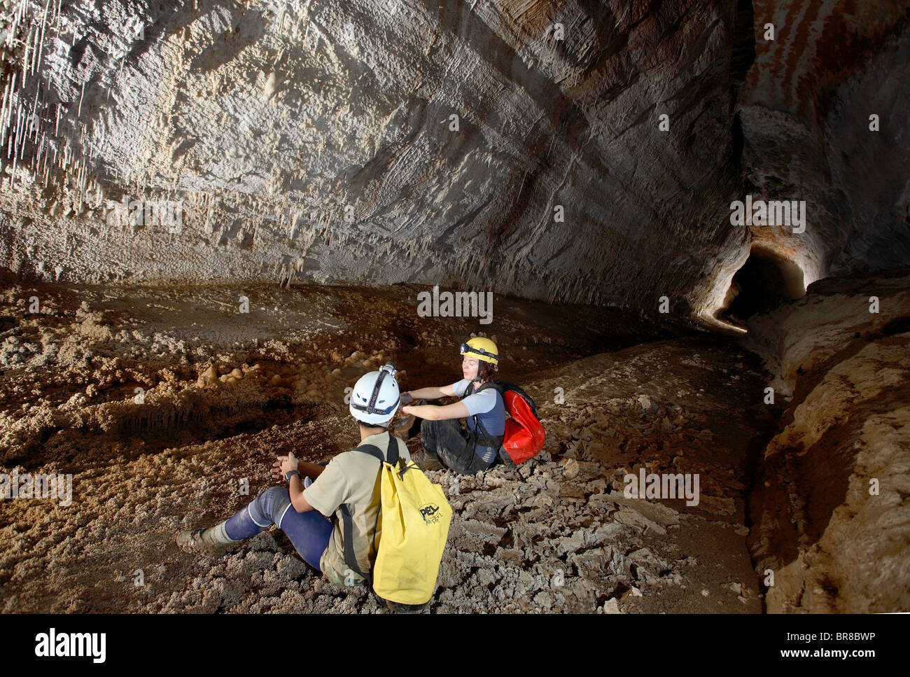 Two female cave explorers stop for a rest whilst exploring this ...