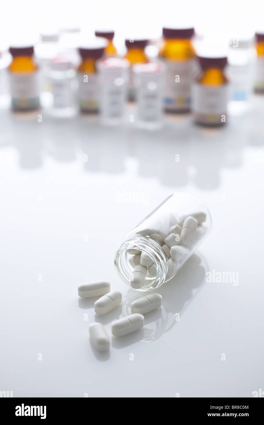 Pills spilling from pill bottle Stock Photo - Alamy