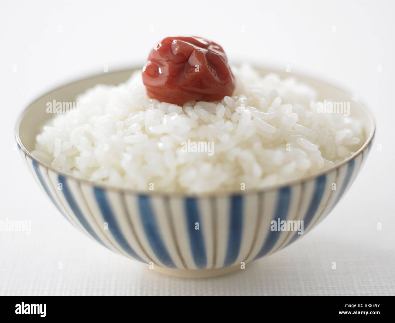 Bowl of rice with pickled plum, close up, white background Stock Photo ...