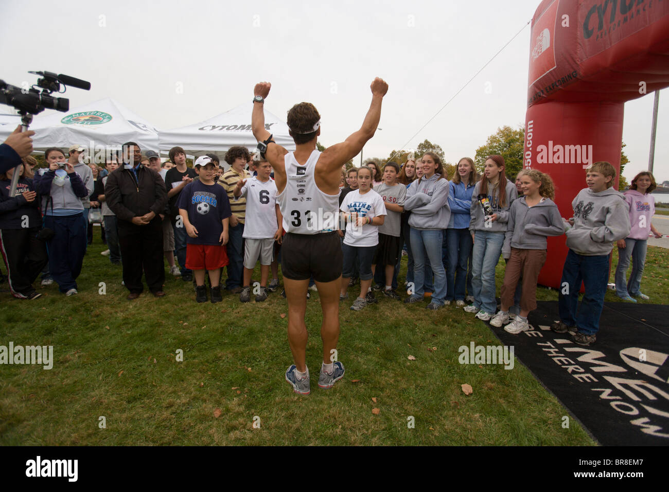 Runner addressing a crowd with arms up after a marathon in Portland ...