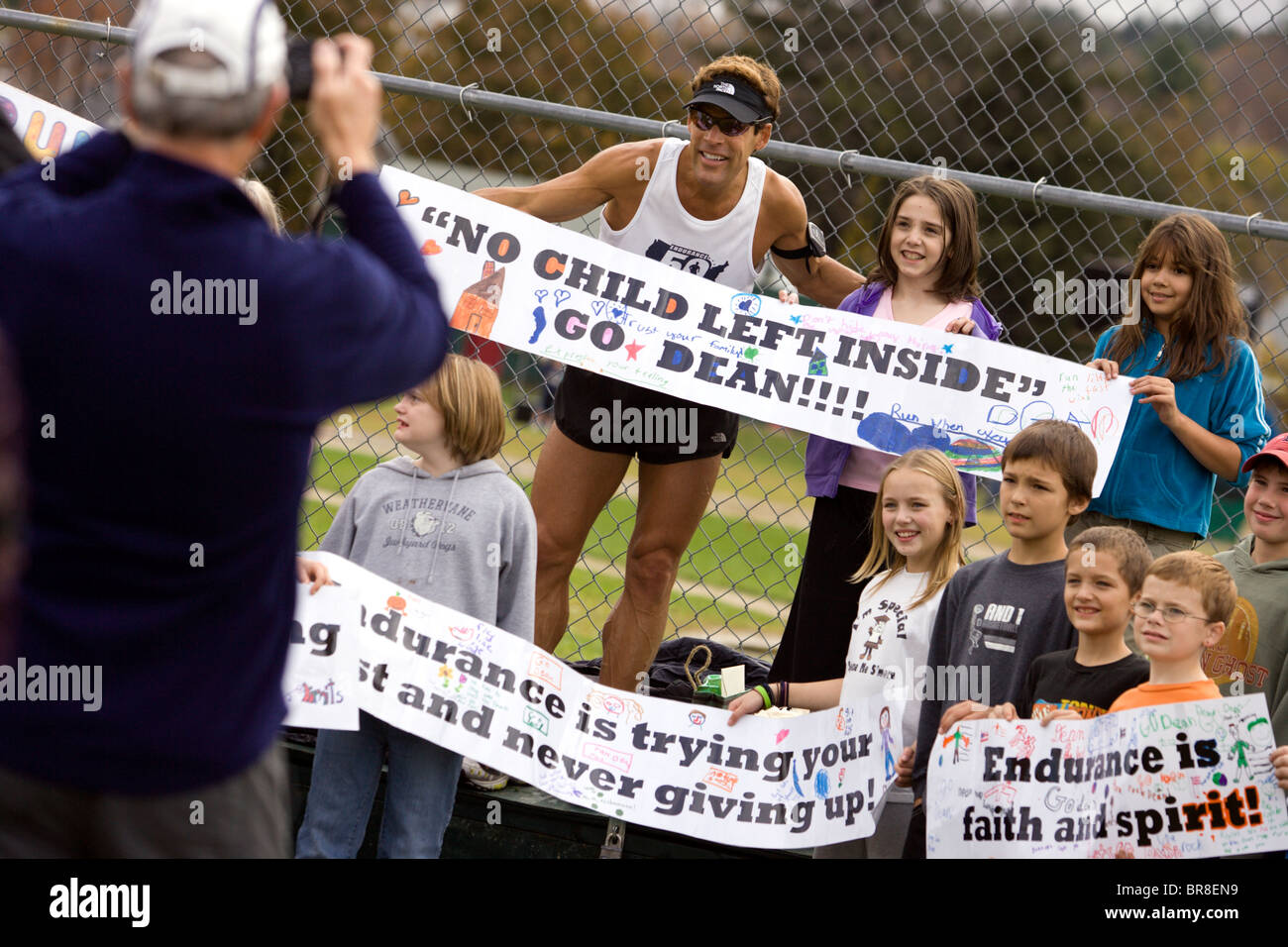 Runner posing for pictures with kids and signs of encouragement after a ...