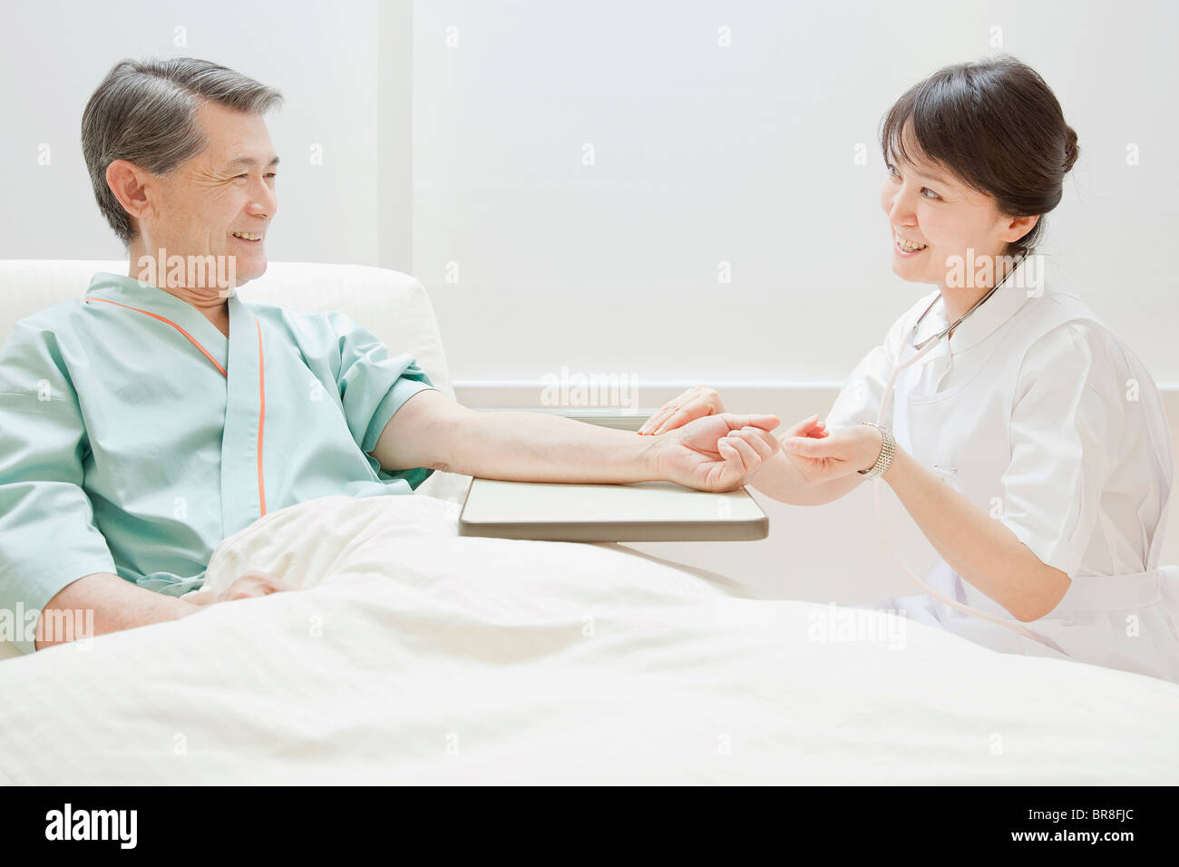 Nurse Checking Senior Man's Pulse Stock Photo - Alamy