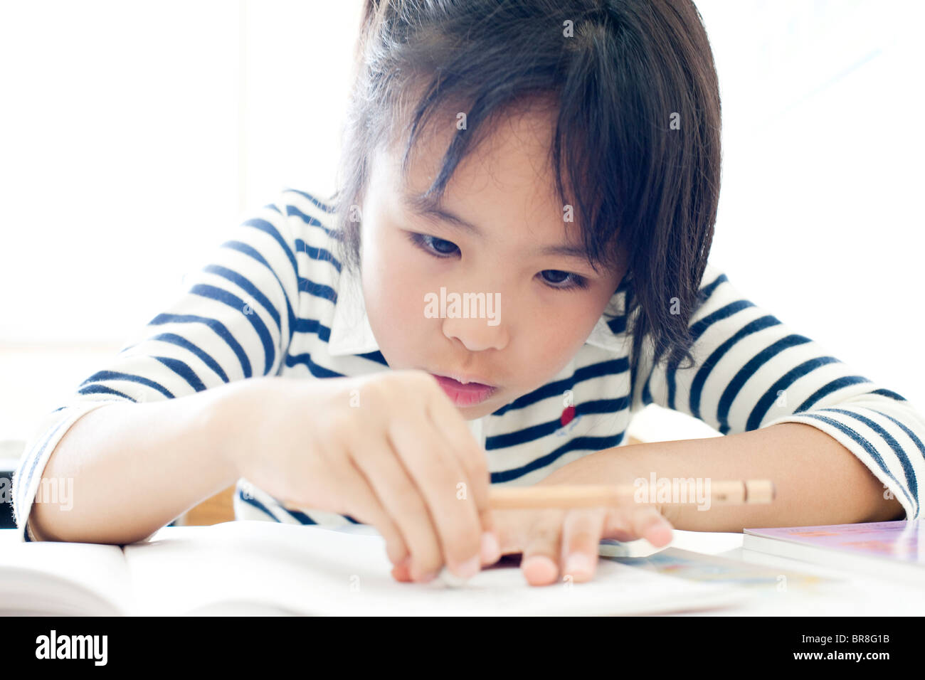 Girl at cram school using an eraser Stock Photo - Alamy