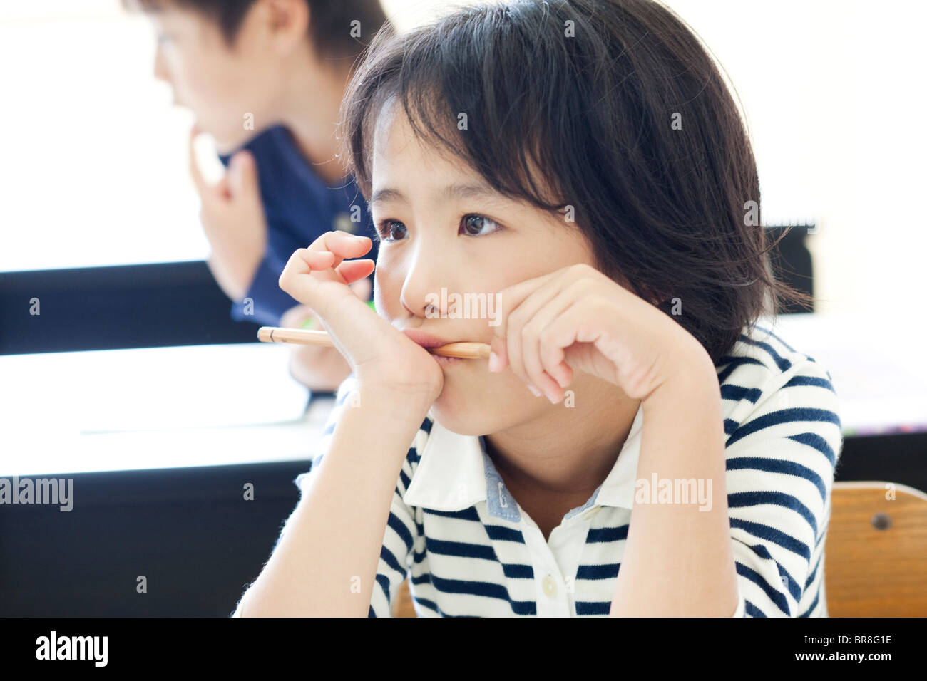 Girl thinking with pencil in her mouth Stock Photo - Alamy