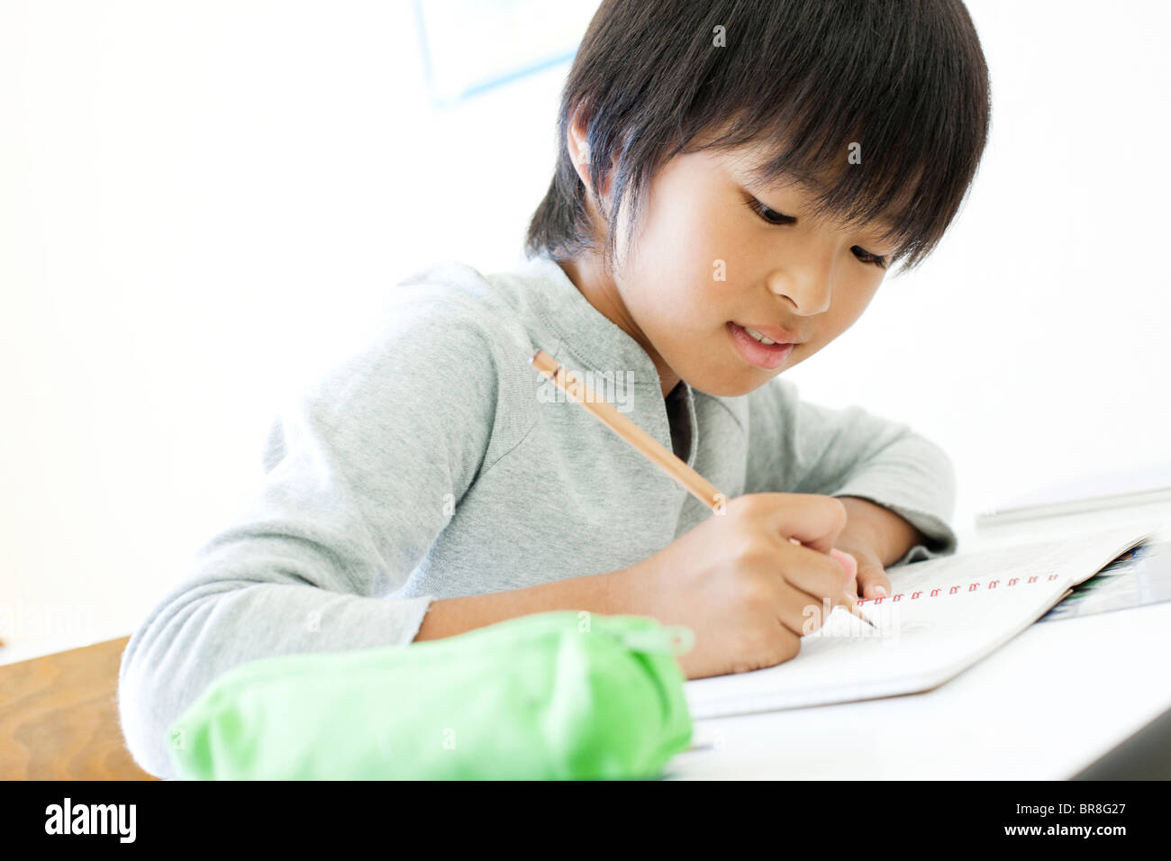 Boy writing on notebook at cram school Stock Photo - Alamy