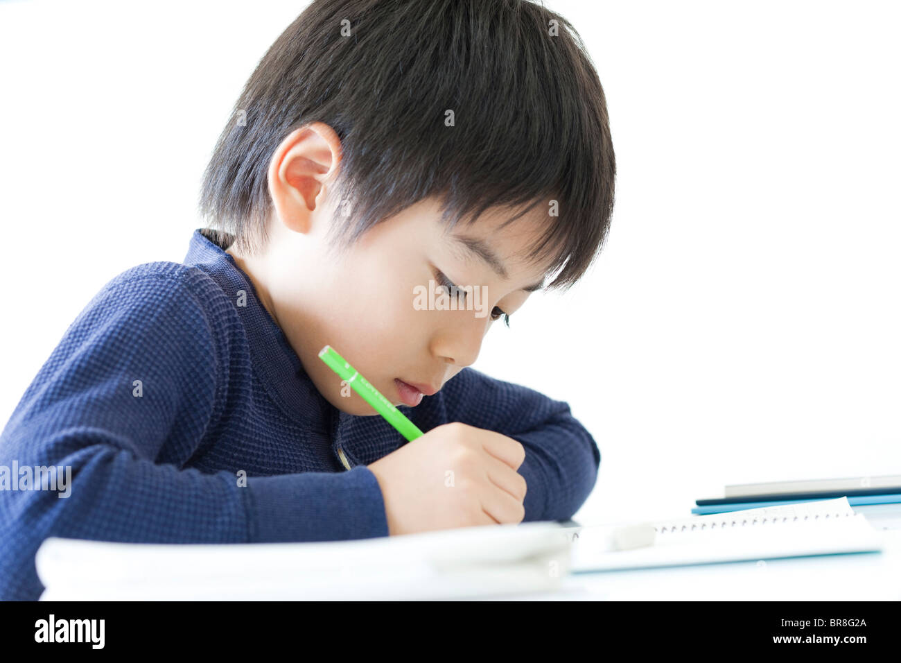 Boy writing on notebook at cram school Stock Photo - Alamy