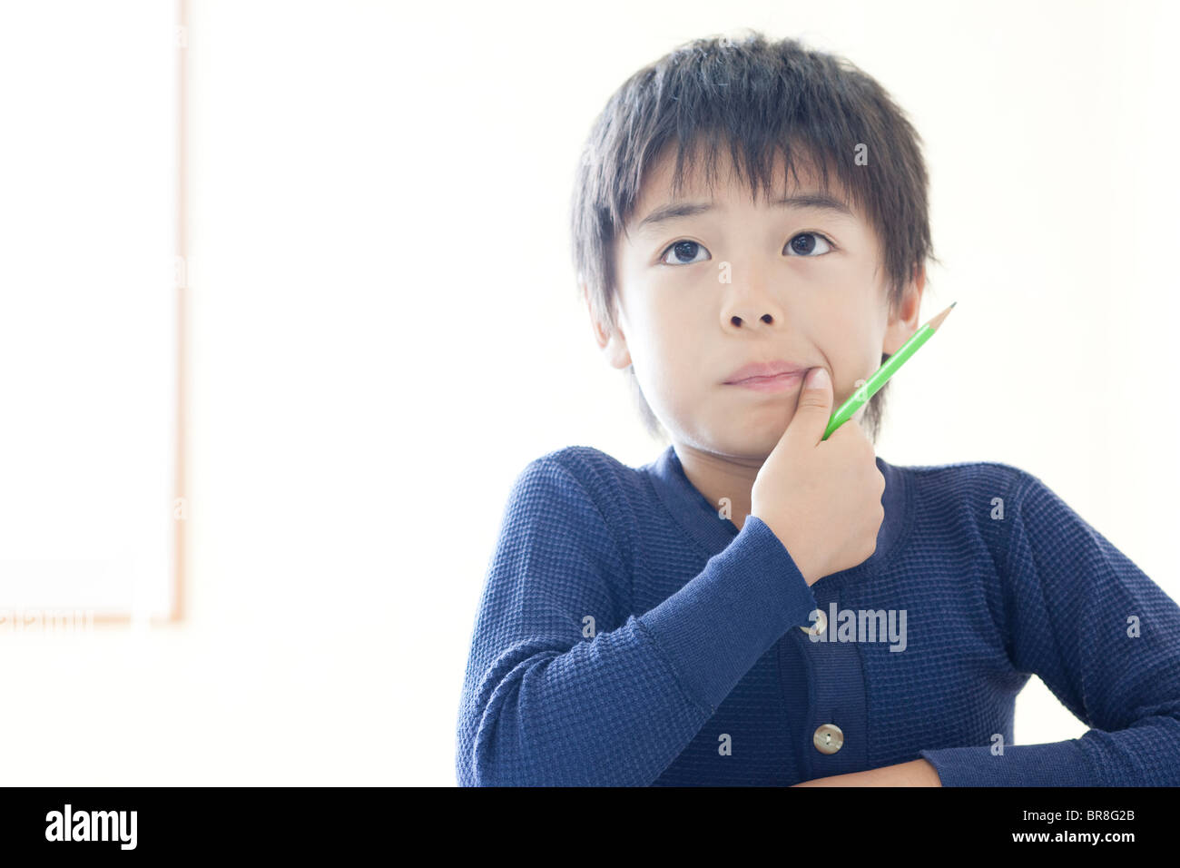 Boy thinking holding a pencil Stock Photo - Alamy