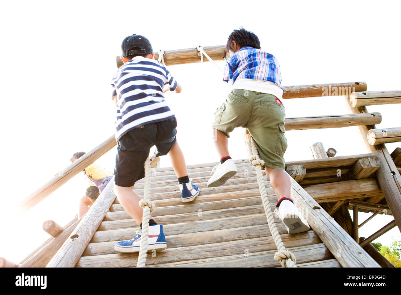 Boys climbing up using a rope Stock Photo - Alamy
