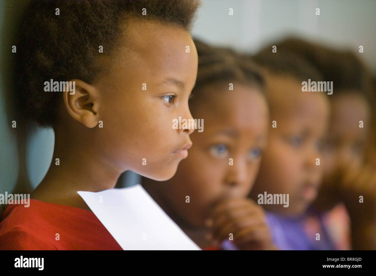 A close up of a girl waiting in line at a Save the Children project ...