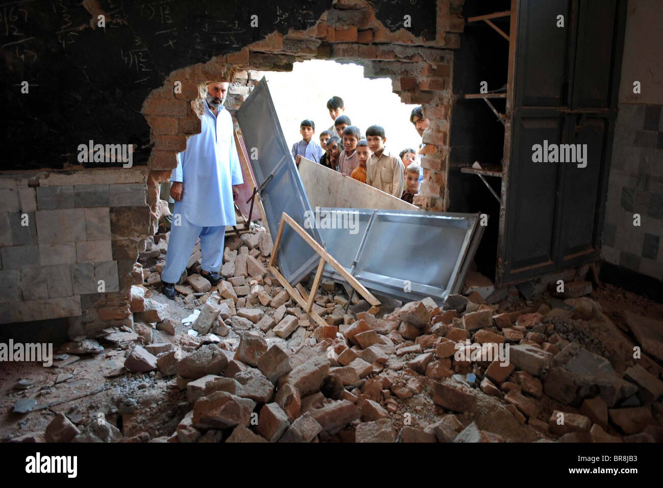 People look damaged wall of a classroom, which was destroyed in bomb ...
