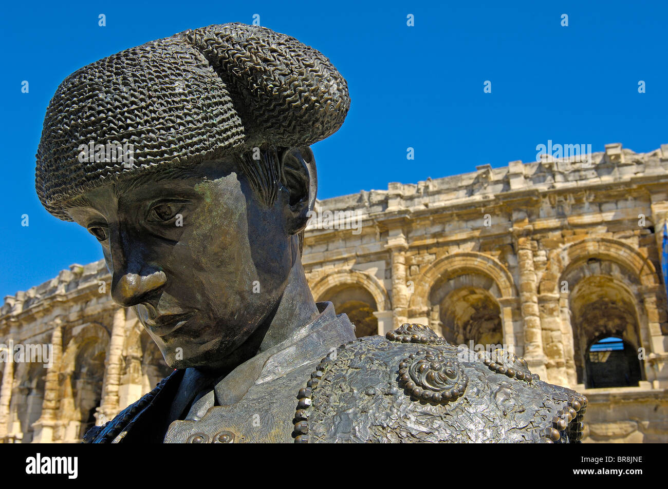 Roman amphitheatre and bullfighter statue. Arénes, Nimes, Gard. Bouches ...