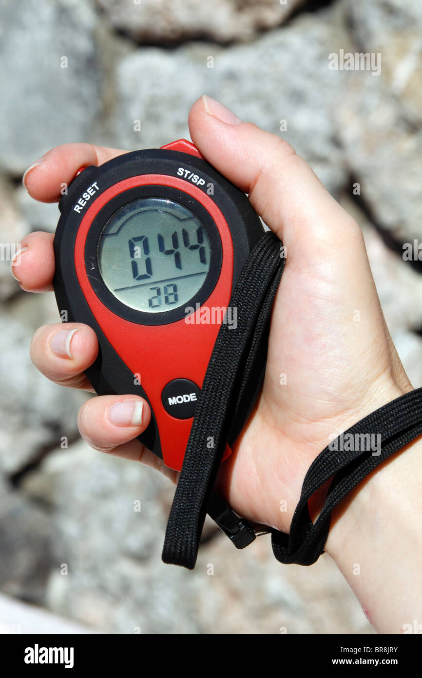 Woman's hand holding a stopwatch Stock Photo - Alamy