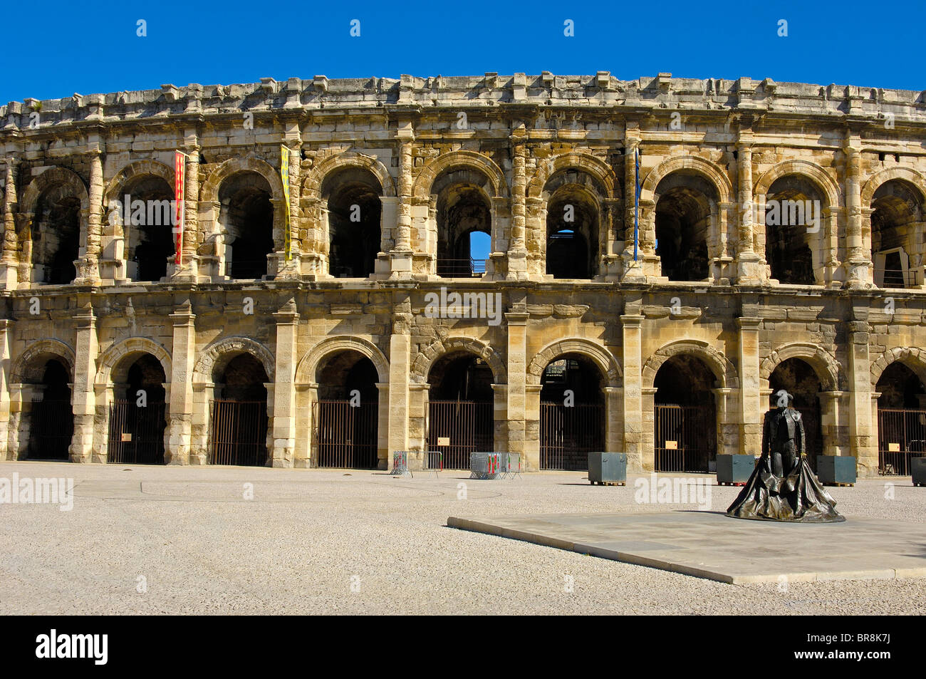Roman amphitheatre and bullfighter statue. Arénes, Nimes, Gard. Bouches ...