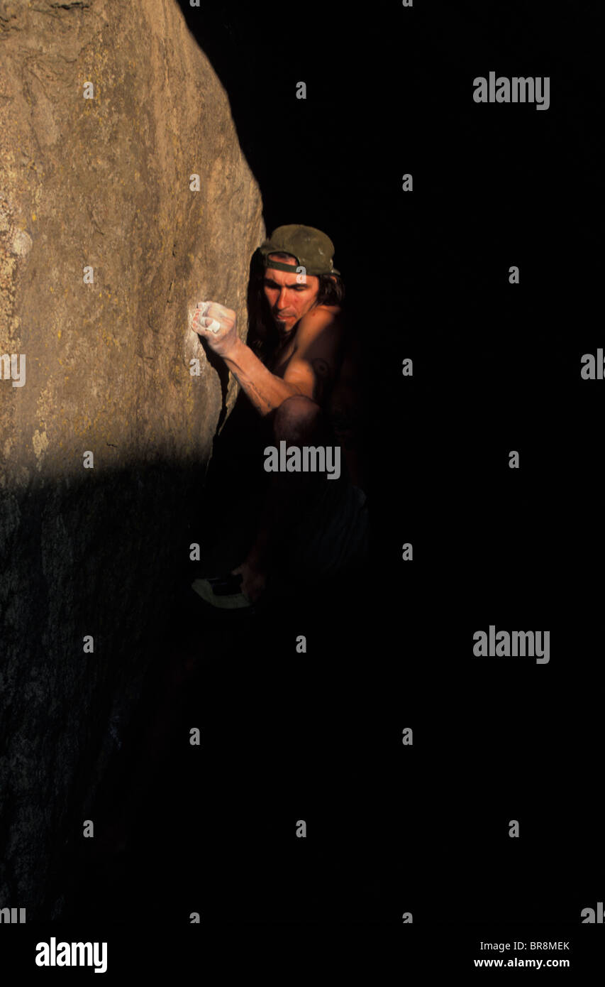 Man climbing out of a dark shadow while bouldering in Rocky Hill ...