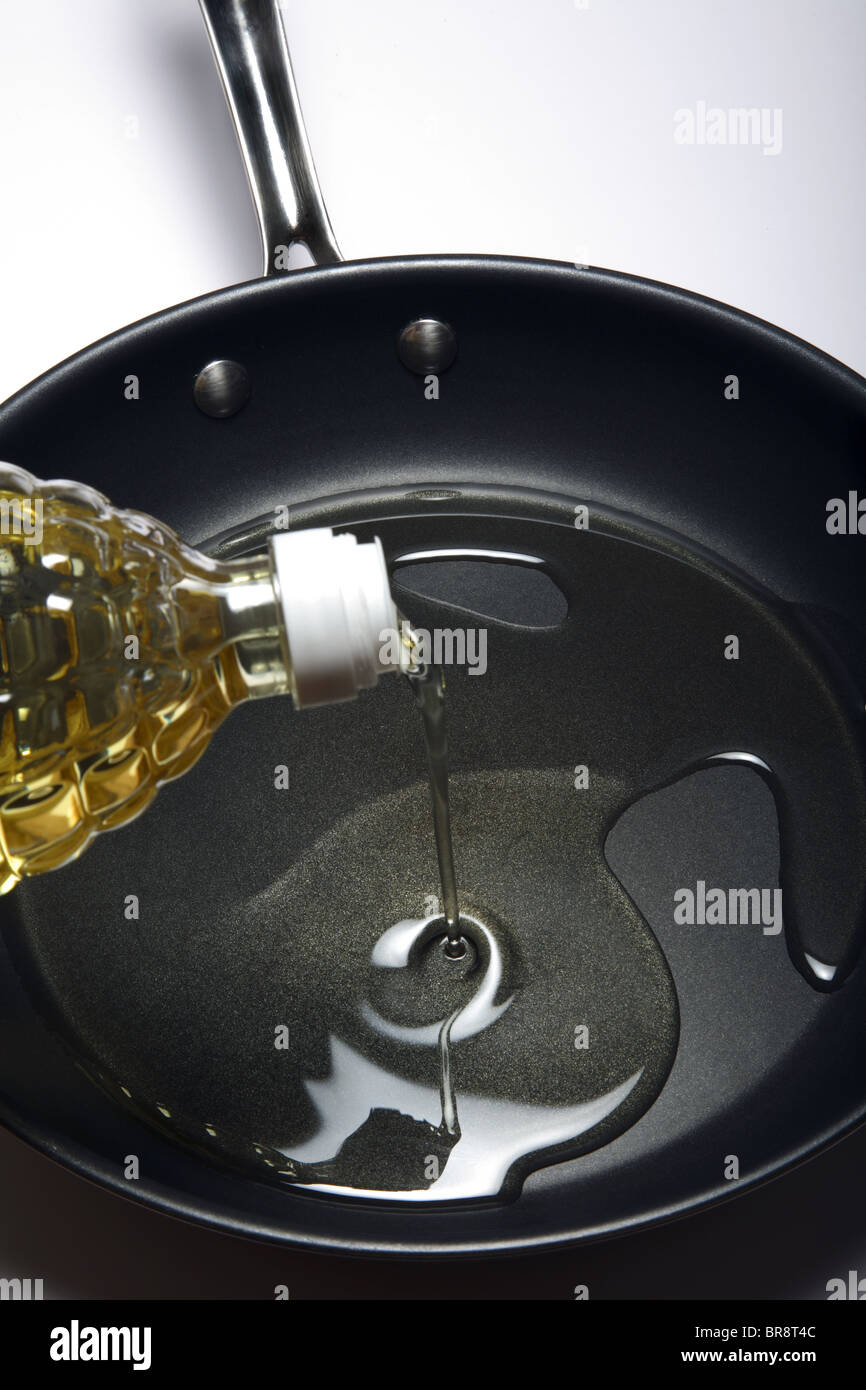 Oil being poured into a frying pan Stock Photo - Alamy